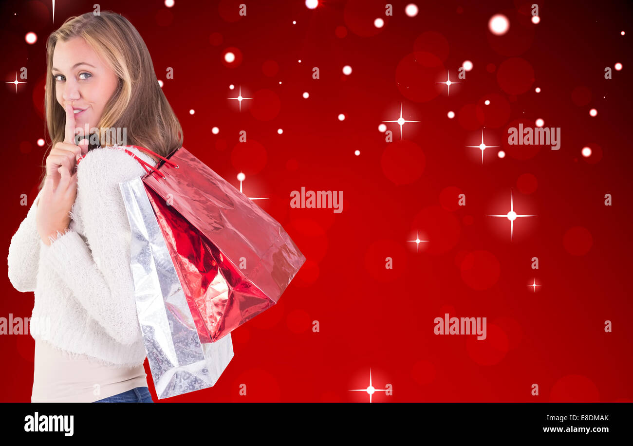 Composite image of pretty blonde keeping a secret holding bags Stock ...
