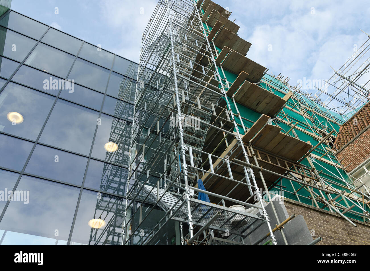 contrasting scaffolding stand alone tower against new modern highly ...