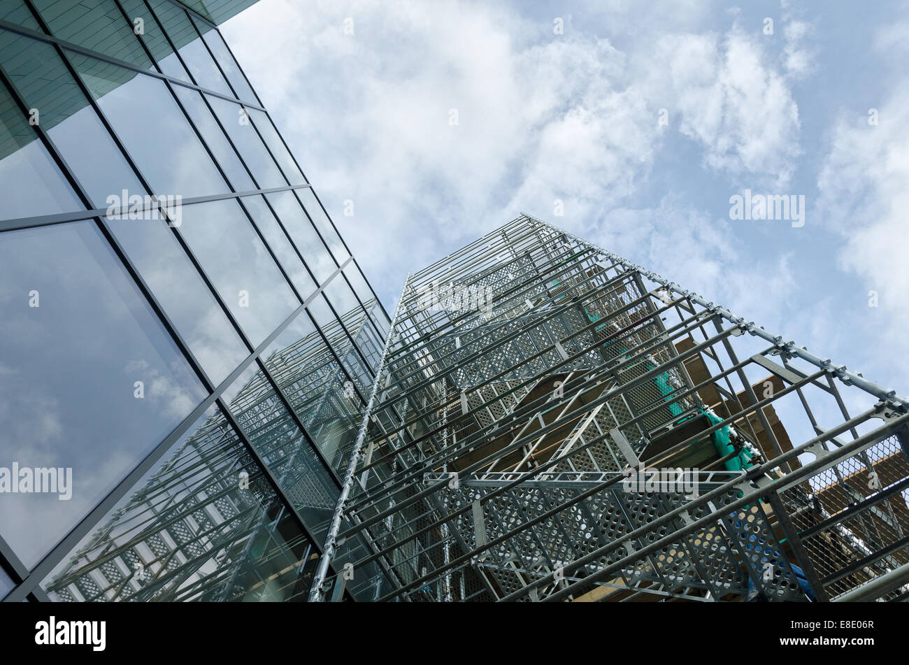 contrasting scaffolding stand alone tower against new modern highly ...