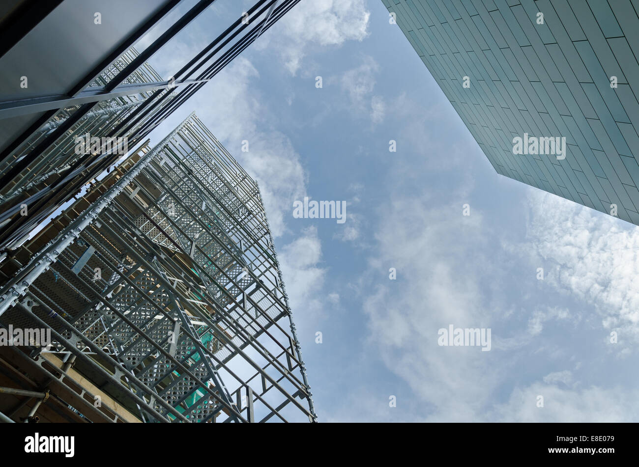 contrasting scaffolding stand alone tower against new modern highly ...