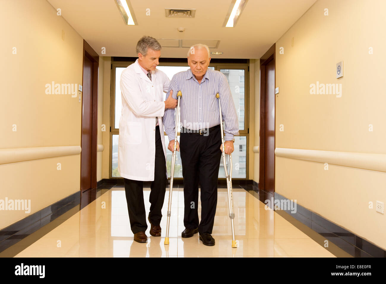 Doctor helping a disabled Stock Photo - Alamy