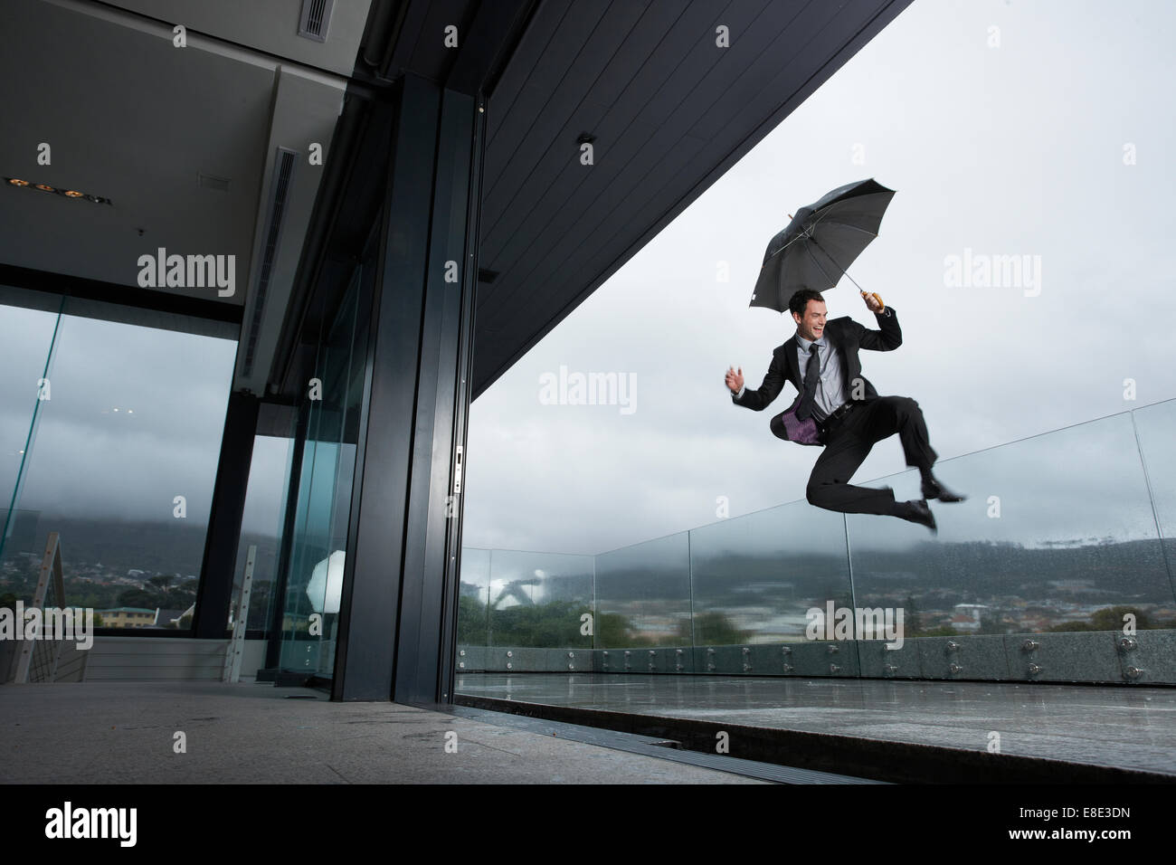 Successful man jumping in the rain Stock Photo - Alamy