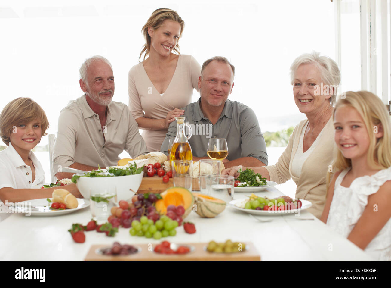 Happy family sitting at a table Stock Photo - Alamy