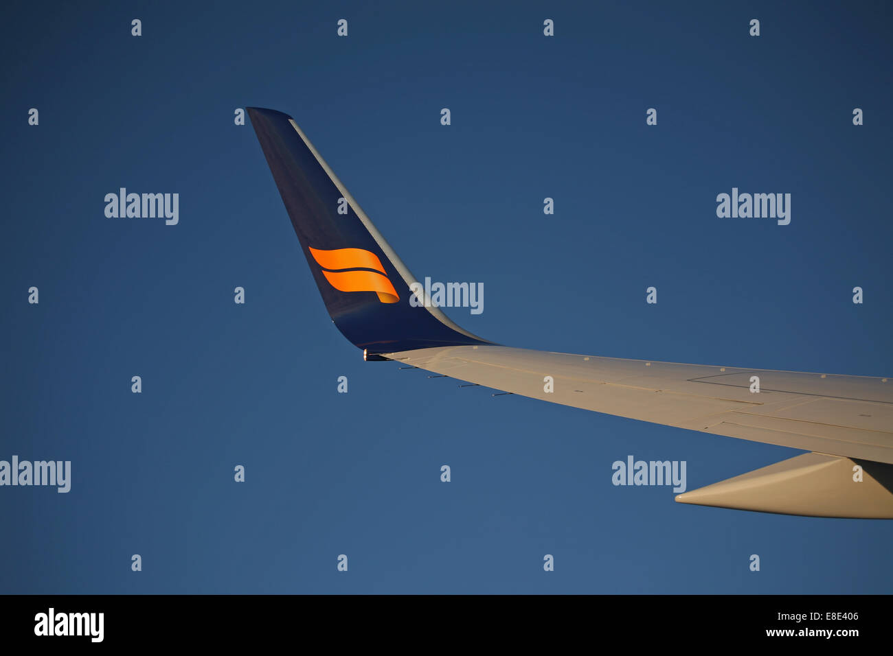 Icelandair logo on a winglet in blue sky flying seen from the cabin ...