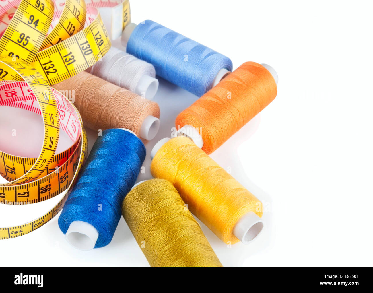 Blue and yellow spools of thread and measuring tape Stock Photo - Alamy