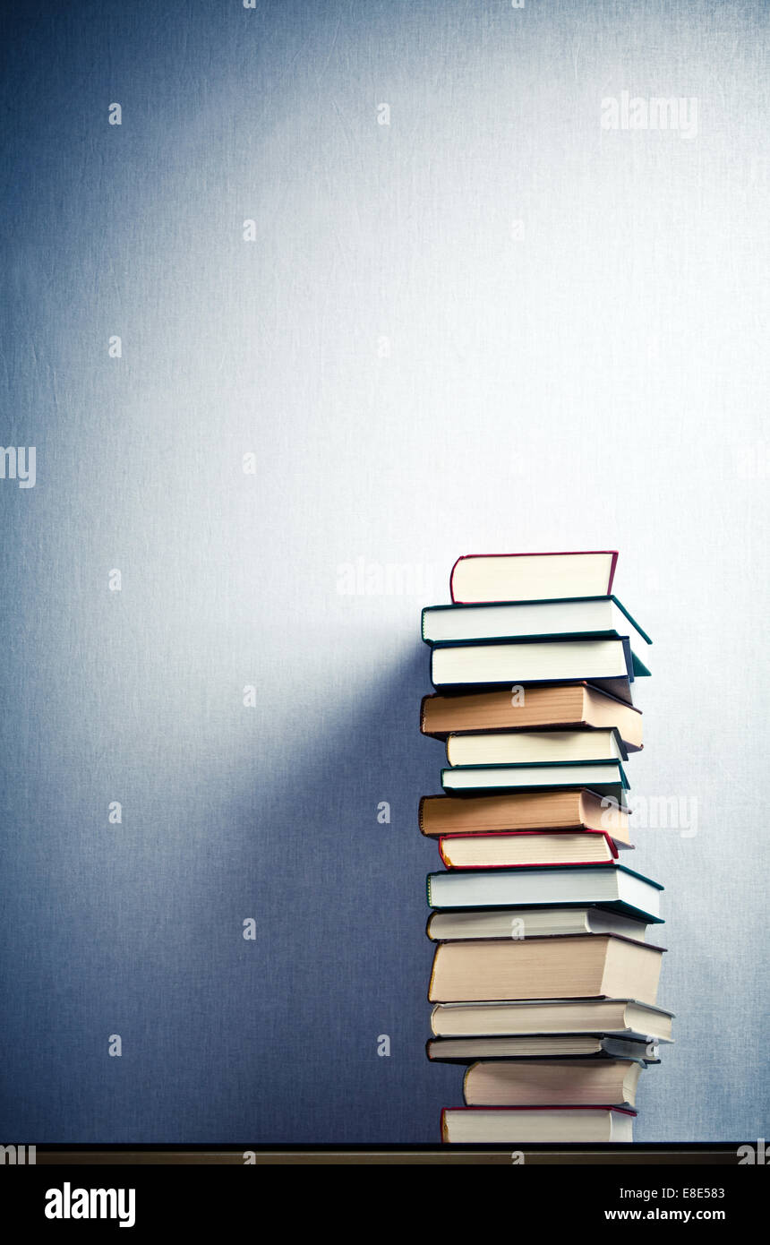 Very high stack of books on a table Stock Photo - Alamy