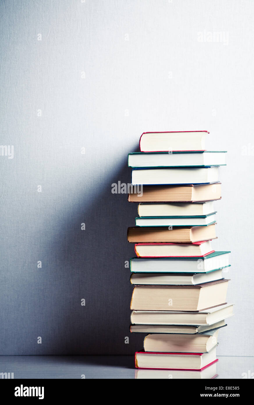 Very high stack of books on a table Stock Photo - Alamy