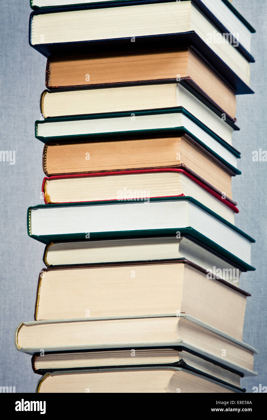 High stack of books over a gray background Stock Photo - Alamy