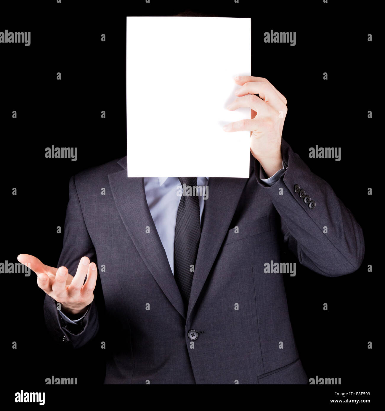 Businessman holding an empty sheet of paper in front of his face ...