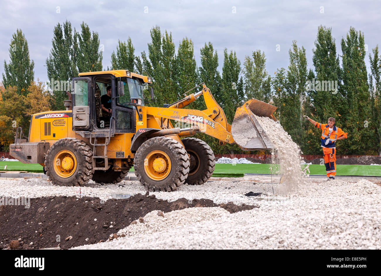 Heavy bulldozer loading and moving gravel on road construction site ...