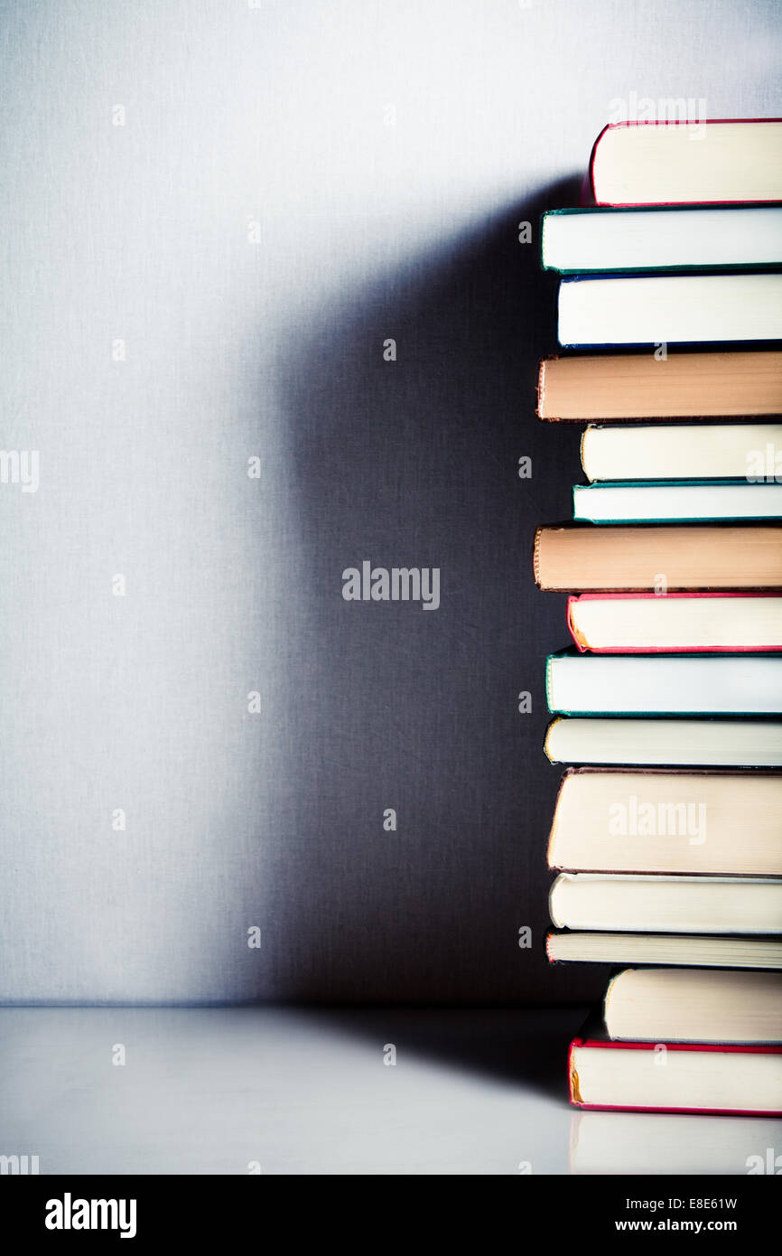 Very high stack of books on a table Stock Photo - Alamy