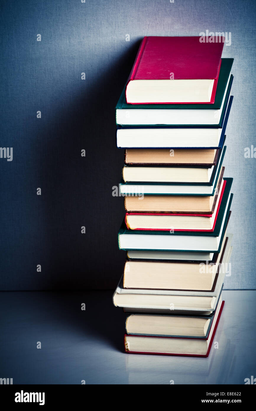 Very high stack of books on a table Stock Photo - Alamy