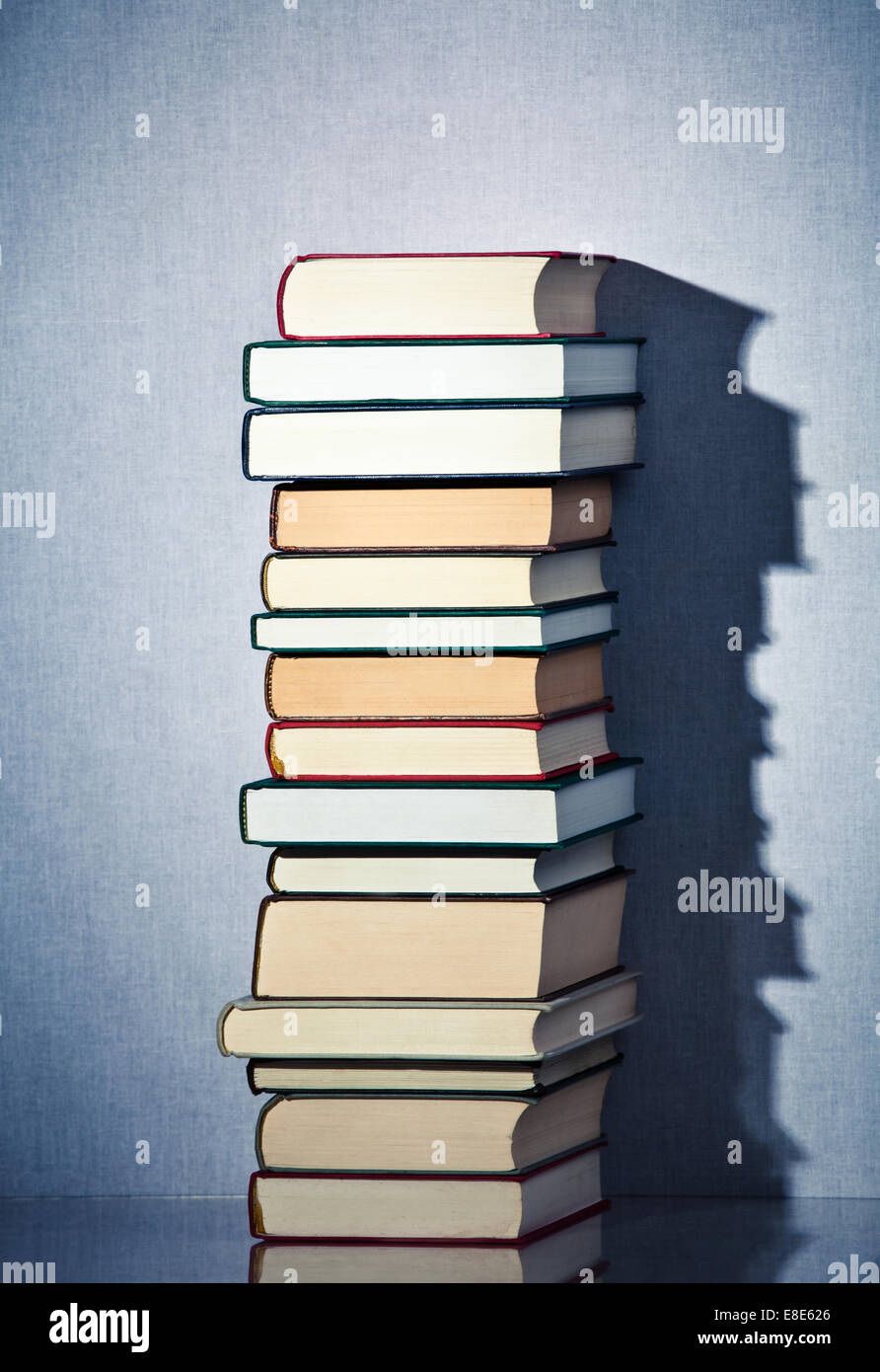 Very high stack of books on a table Stock Photo - Alamy
