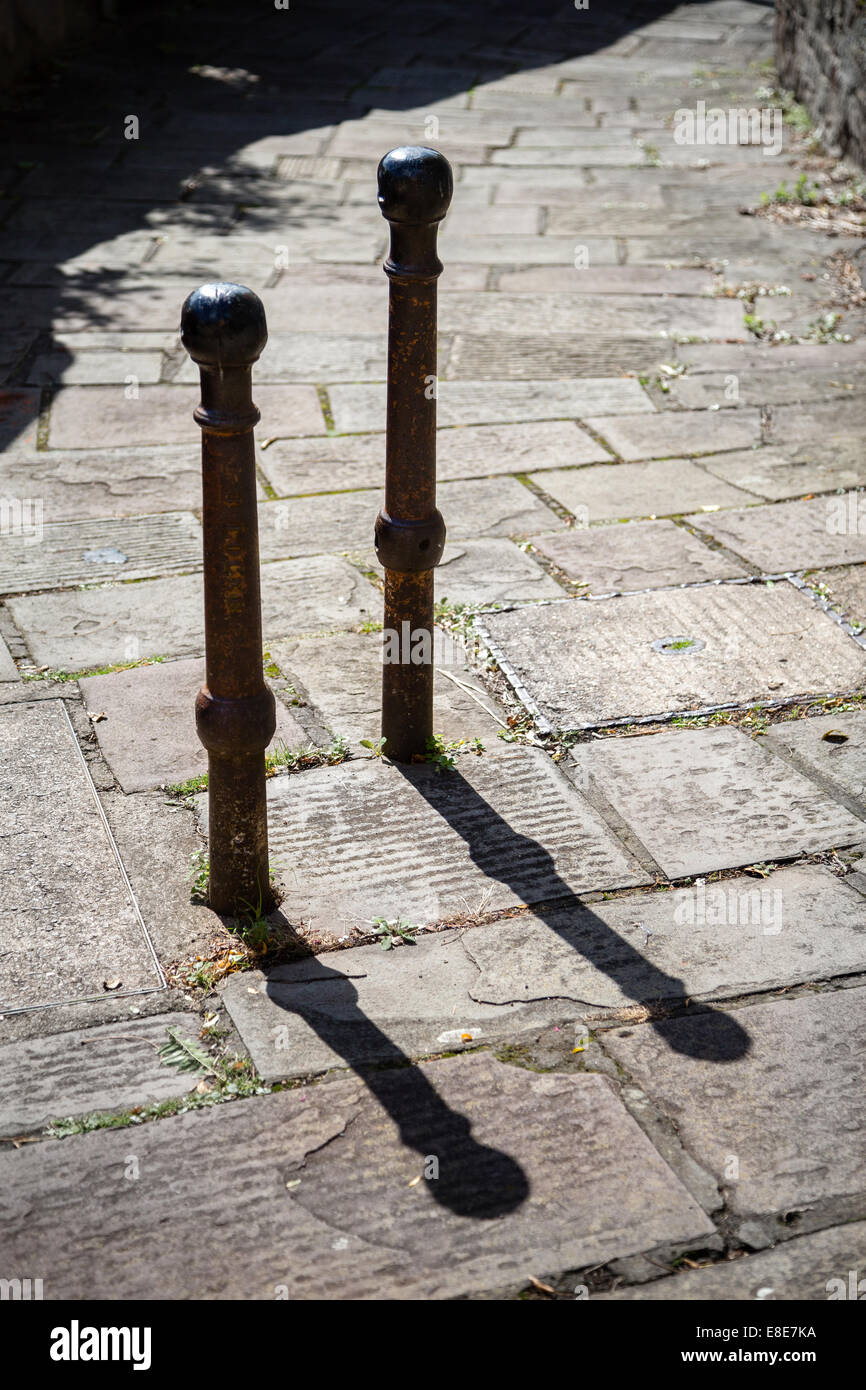 Pair of Victorian iron bollards on a York stone pavement in Bristol in ...