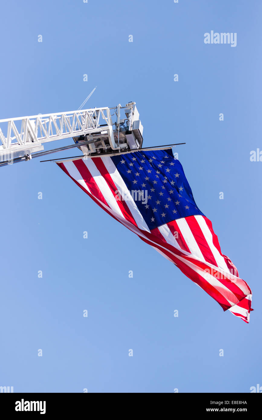 An American Flag is flying from an extended fire department ladder ...