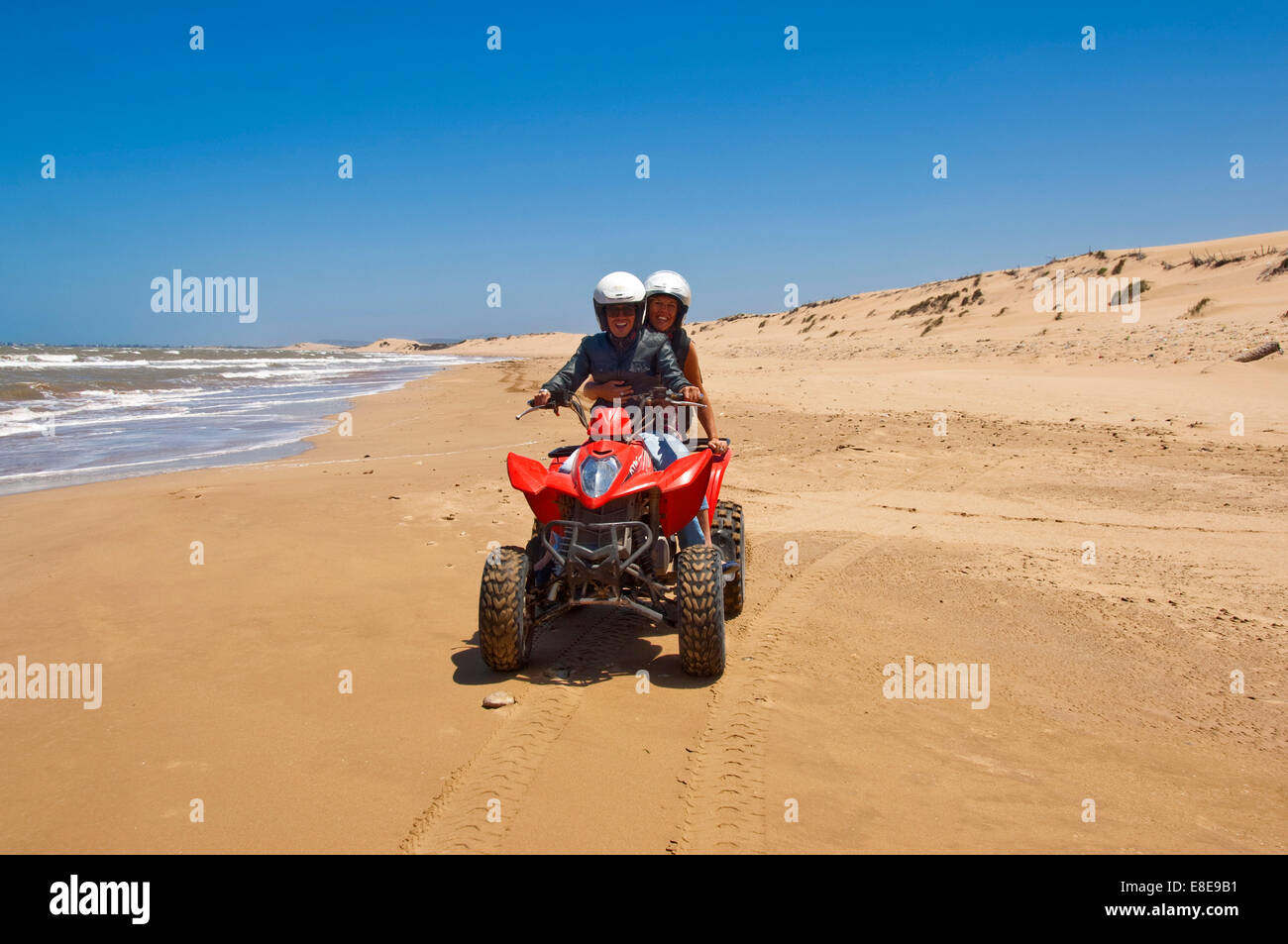 Horizontal portrait of a young man and woman on a quad bike on the ...