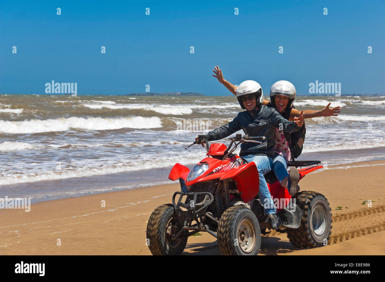 Horizontal portrait of a young man and woman on a quad bike on the ...