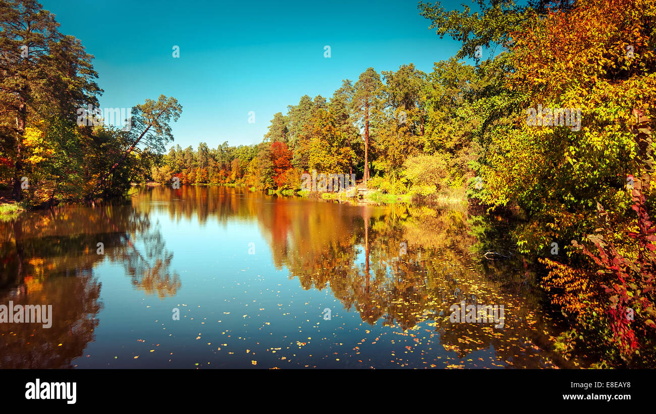 Sunny day in outdoor park with lake and colorful autumn trees ...