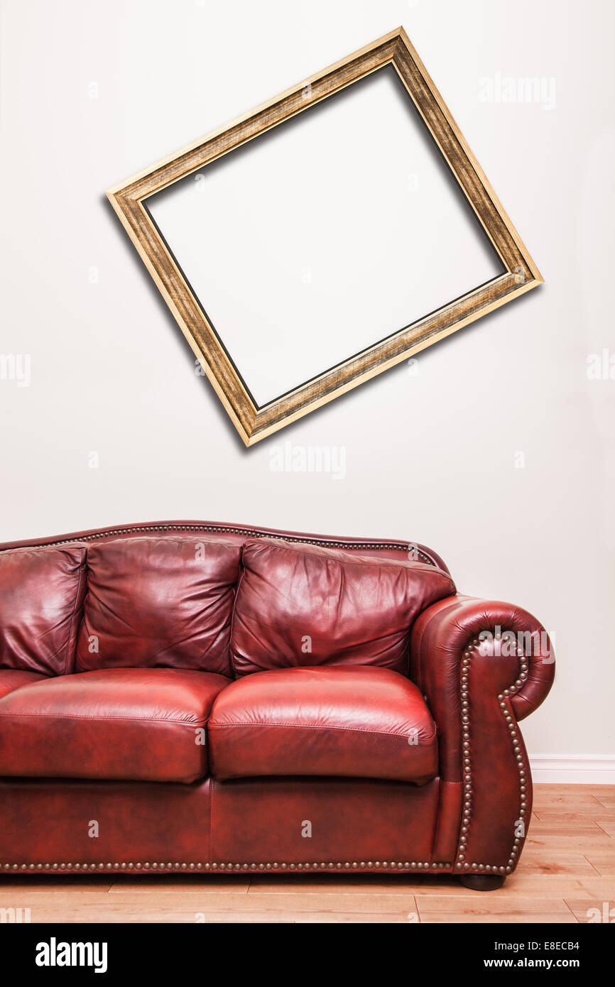 Luxurious Red Leather Couch in front of a blank crooked frame to ad ...