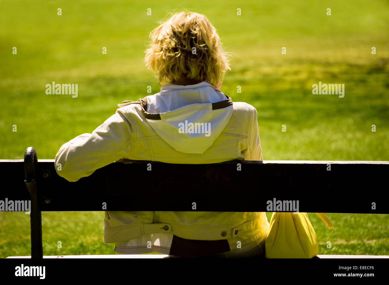 woman sitting on a bench in sunshine Stock Photo - Alamy