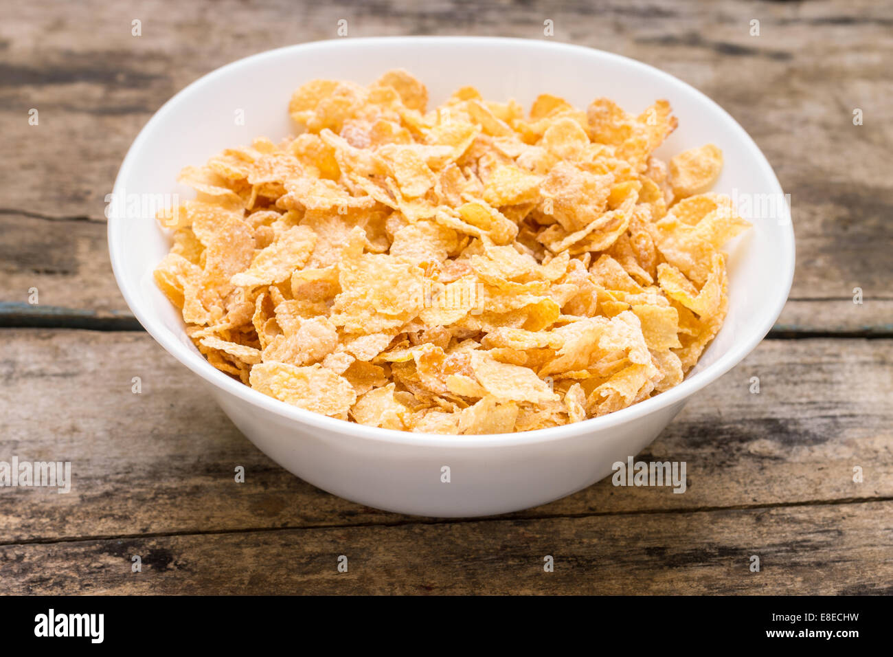 Healthy eating background. Corn flakes in white plate on wooden table ...