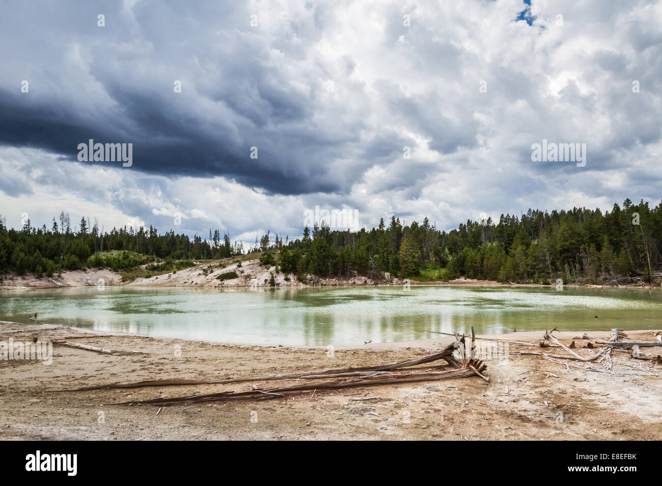 mineral pool in yellowstone national park with storm clouds building up ...
