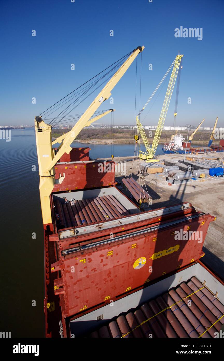 Crane Offloading Pipe from Cargo Ship Stock Photo - Alamy