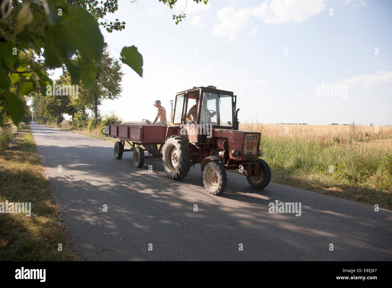 Small Polish tractor pulling a farm wagon on a country road. Zawady ...