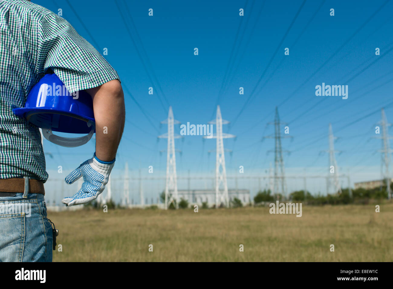 back view, closeup of male engineer standing at electricity station ...