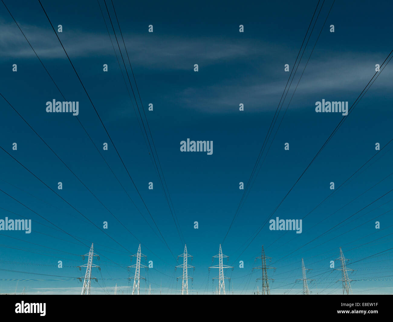 perspective view of electricity power lines on blue sky background ...