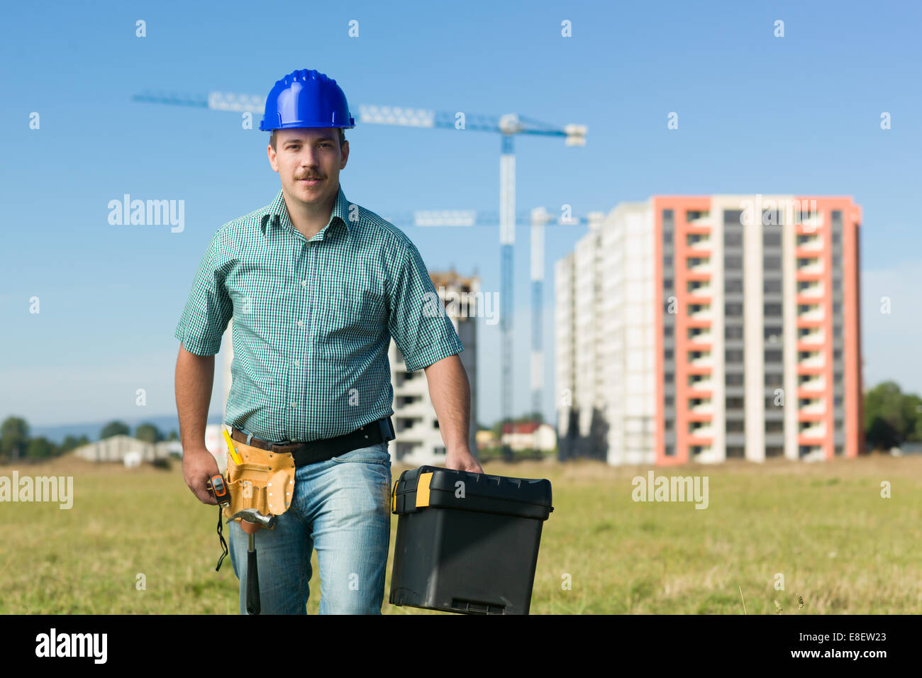 front view of confindent caucasian engineer holding tool box on ...