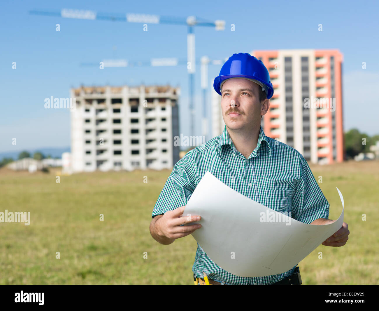male engineer holding blueprint on construction site Stock Photo - Alamy