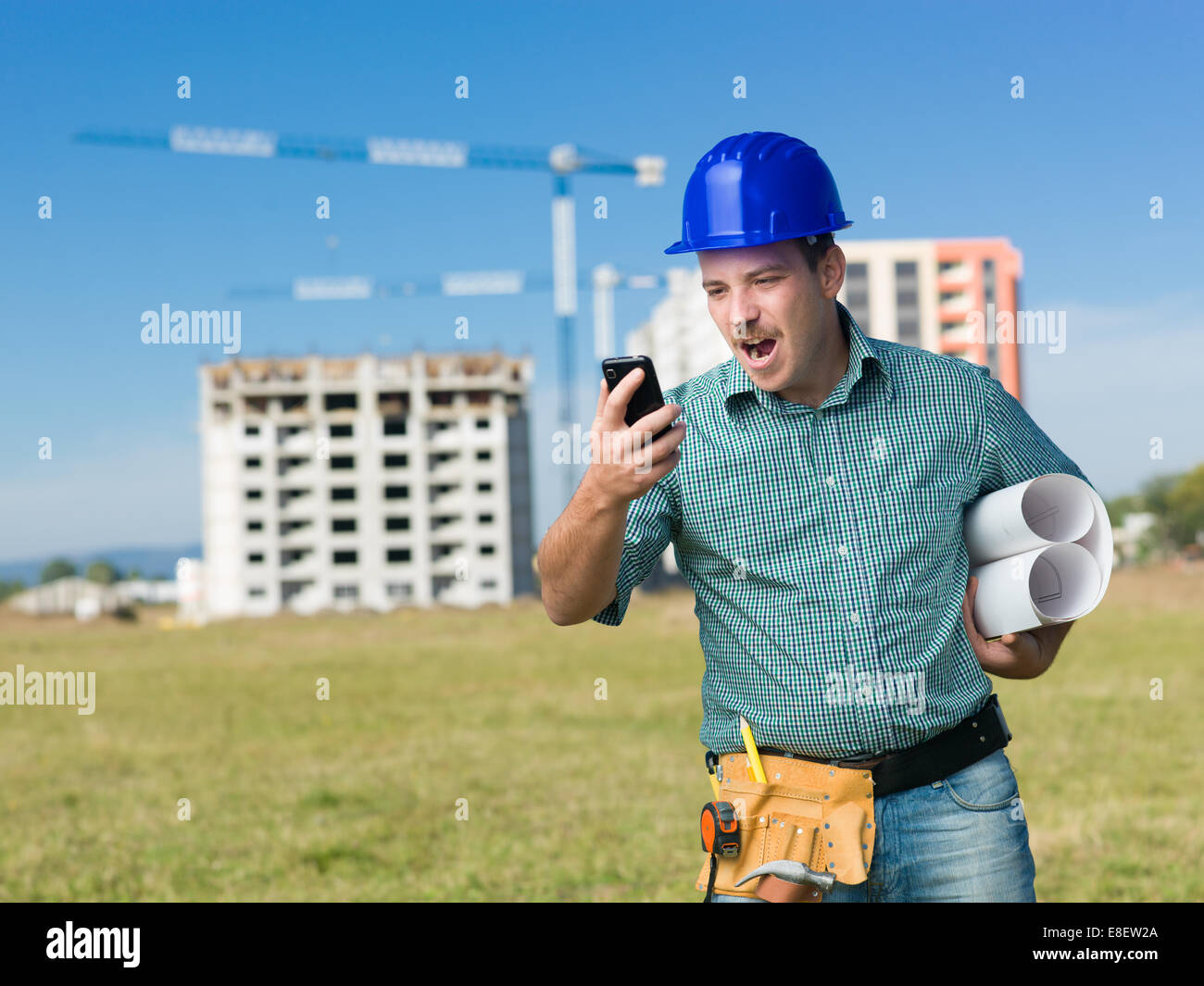 portrait of angry engineer standing on construction site, yelling at ...