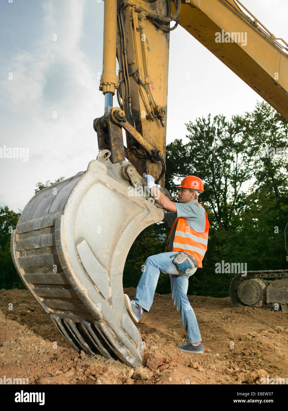 male engineer repairing excavator on construction site, outdoors Stock ...