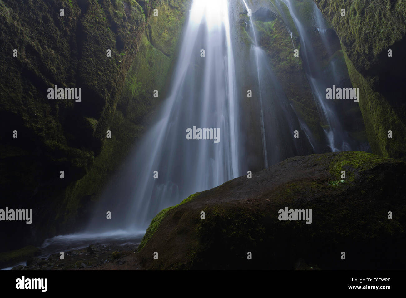 Waterfall, 50m, cascading into a ravine overgrown by moss ...