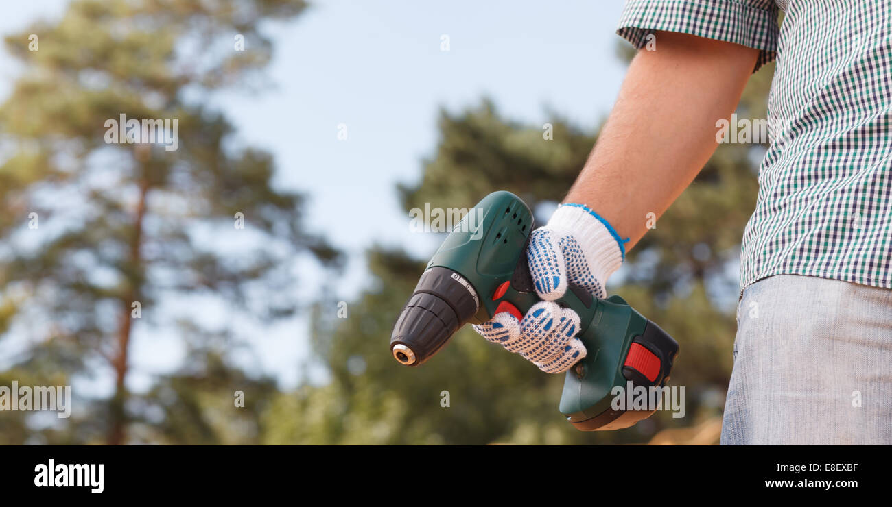 Construction worker is holding an electric drill hi-res stock ...