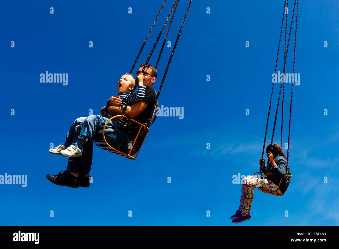 Young people on the swinging carousel ride chain swing Stock Photo - Alamy