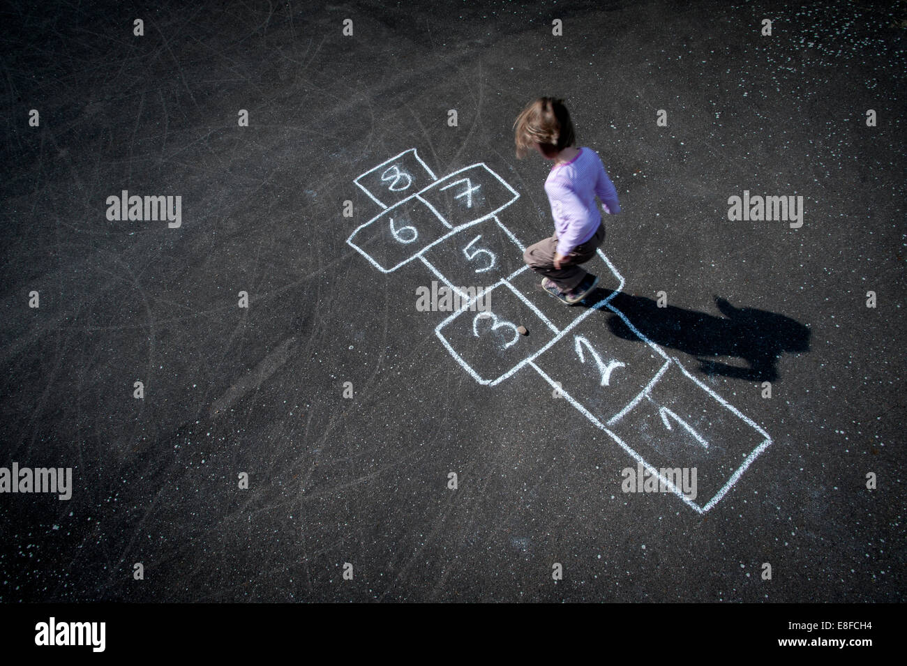 Girl playing traditional hopscotch game hi-res stock photography and ...