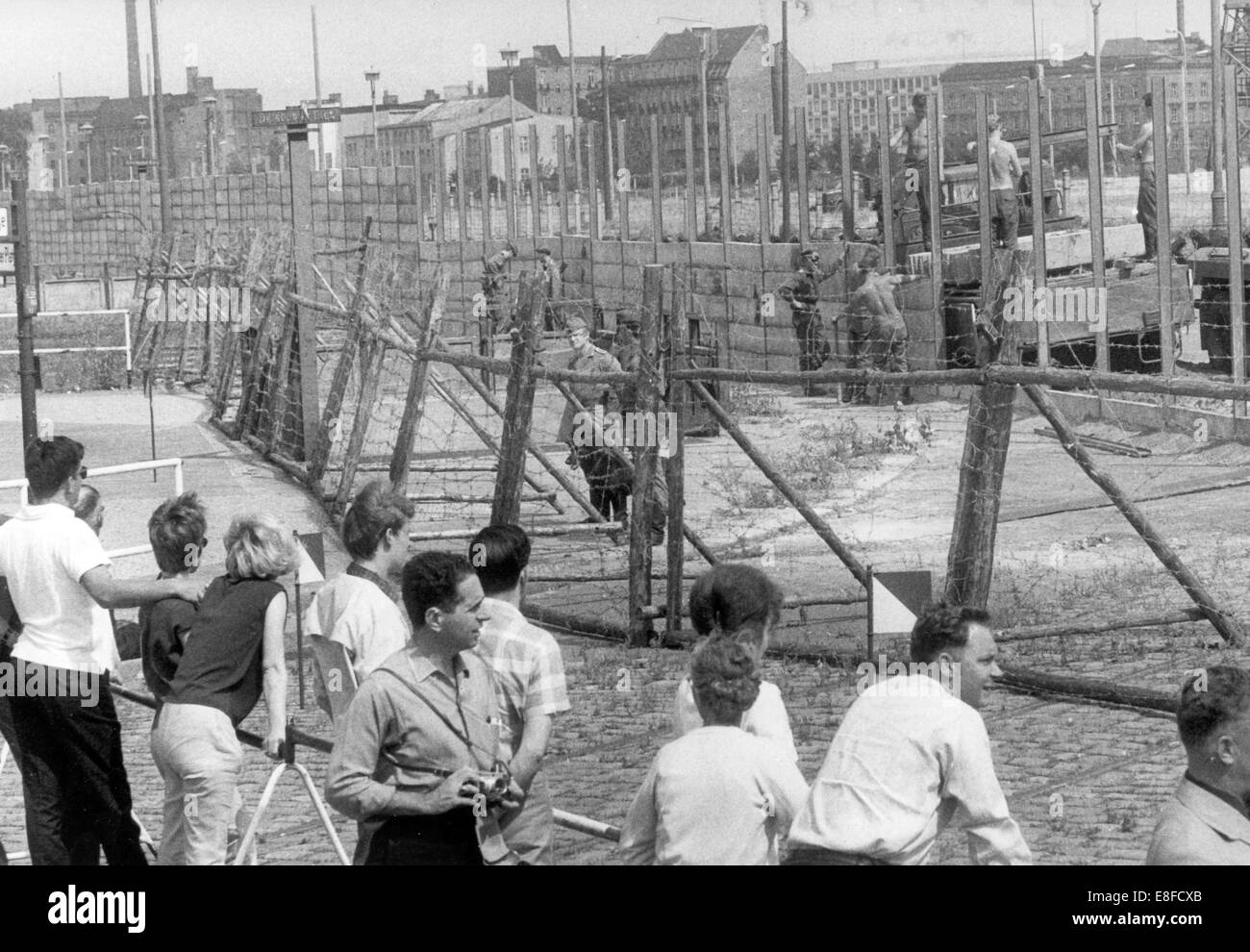 Citizens from West Berlin watch border guards from East Berlin ...