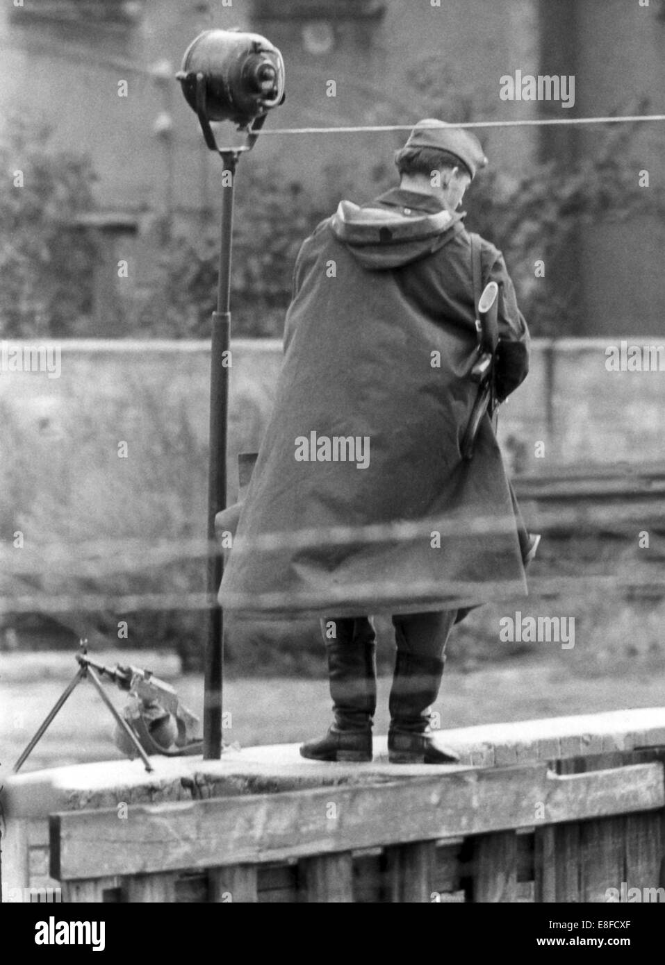 A GDR border soldier patrols with rifle on Berlin Wall on the 8th of ...