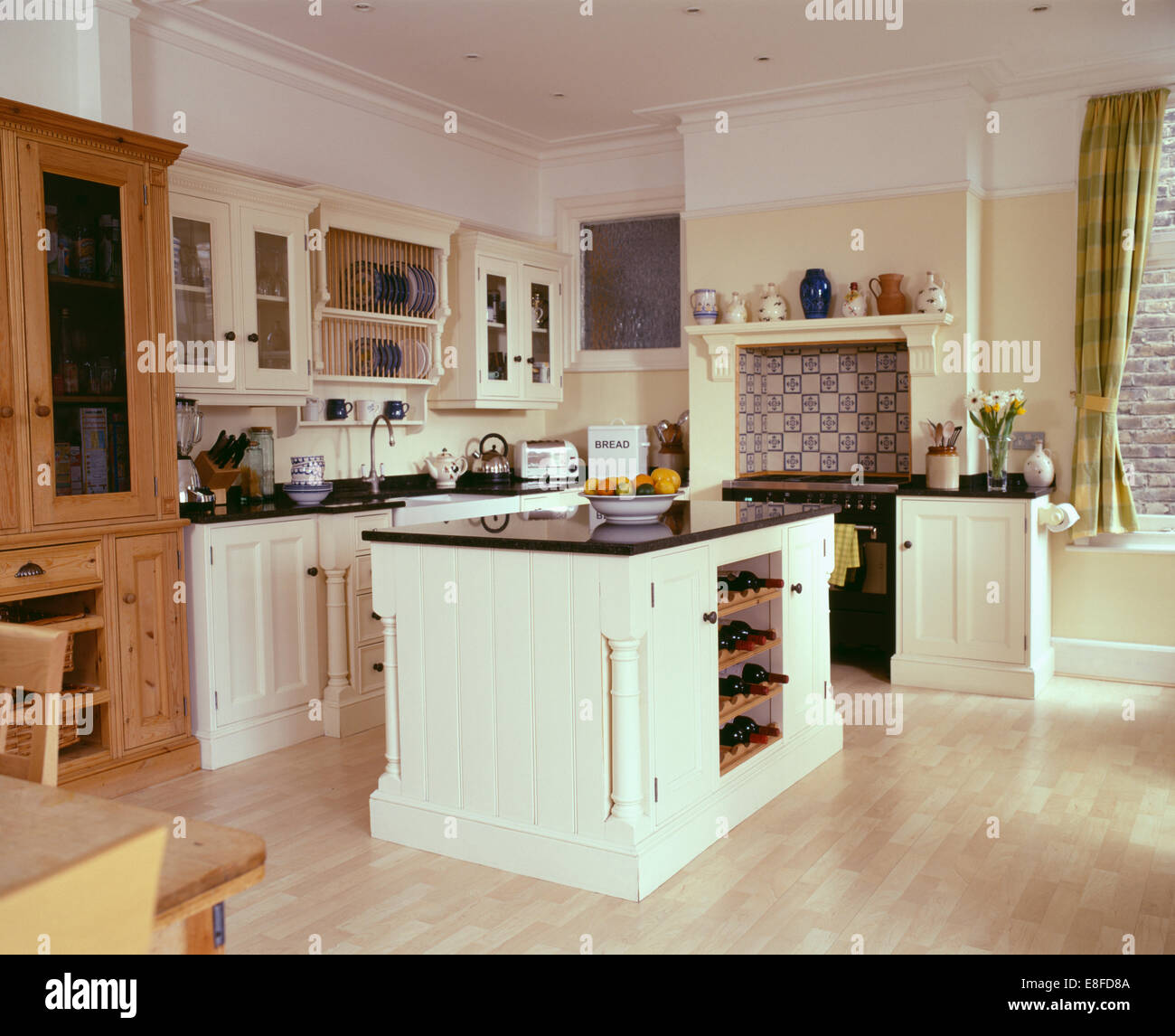Granite-topped island unit in cream townhouse kitchen with wooden ...