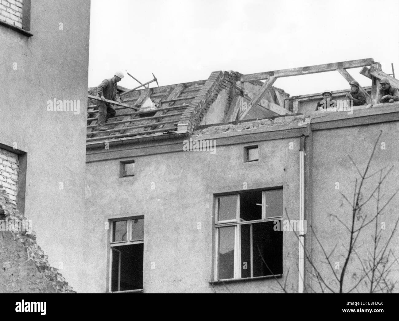 Building workers from East Berlin are tearing down bordering houses in ...