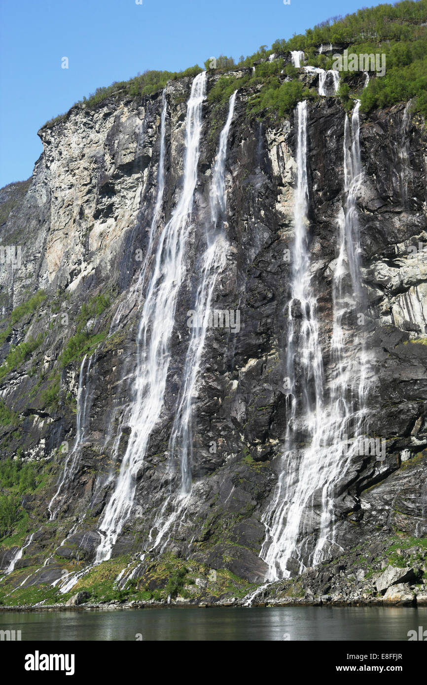 Waterfall flowing down cliff into fjord, Norway Stock Photo - Alamy