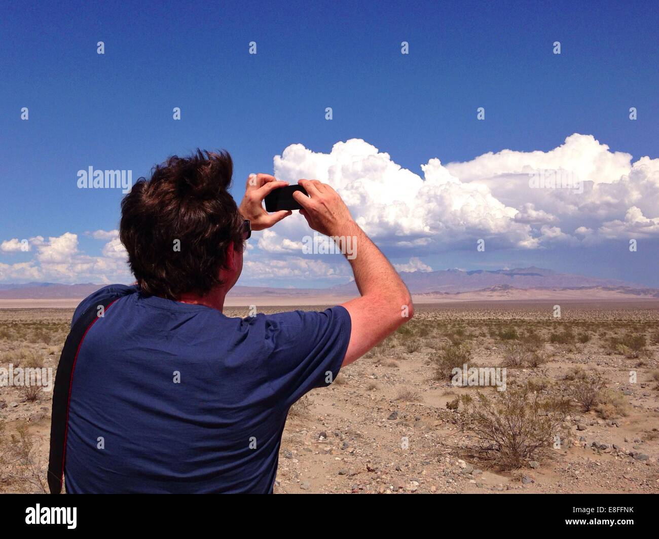 Man standing in the Mojave desert taking a photo, California, USA Stock ...