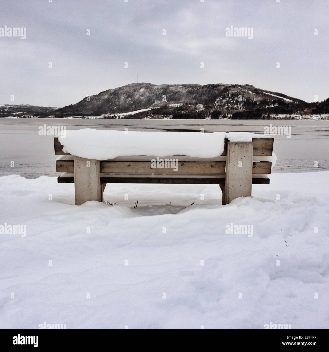 Snow covered bench by fjord, Norway Stock Photo - Alamy