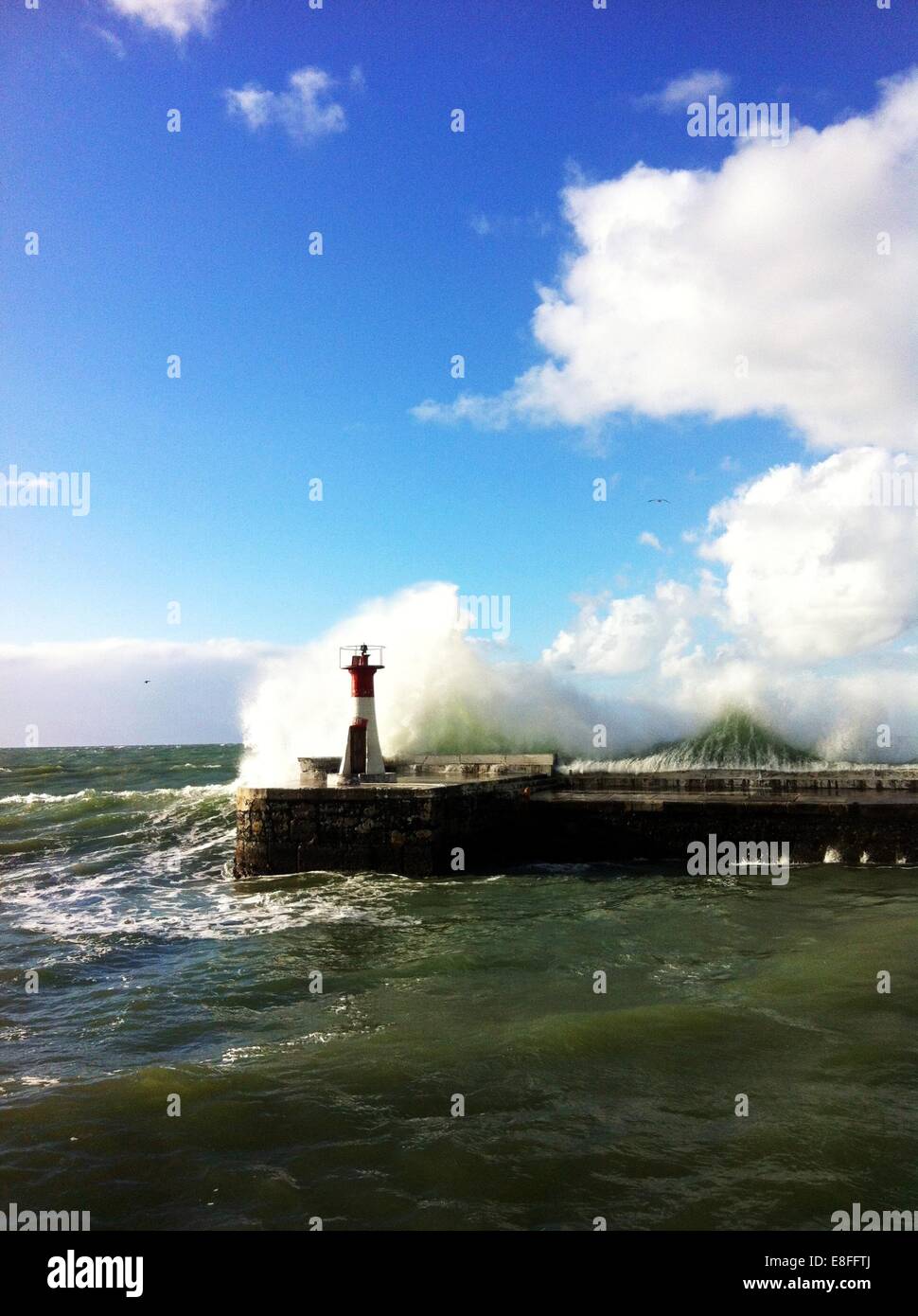 Waves crashing against lighthouse tower Stock Photo - Alamy