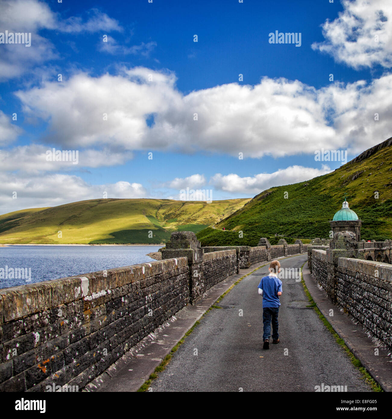 Boy walking across a bridge Stock Photo - Alamy