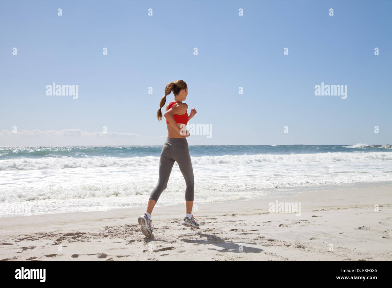 Woman running on beach, Cape Town, Western Cape, South Africa Stock ...
