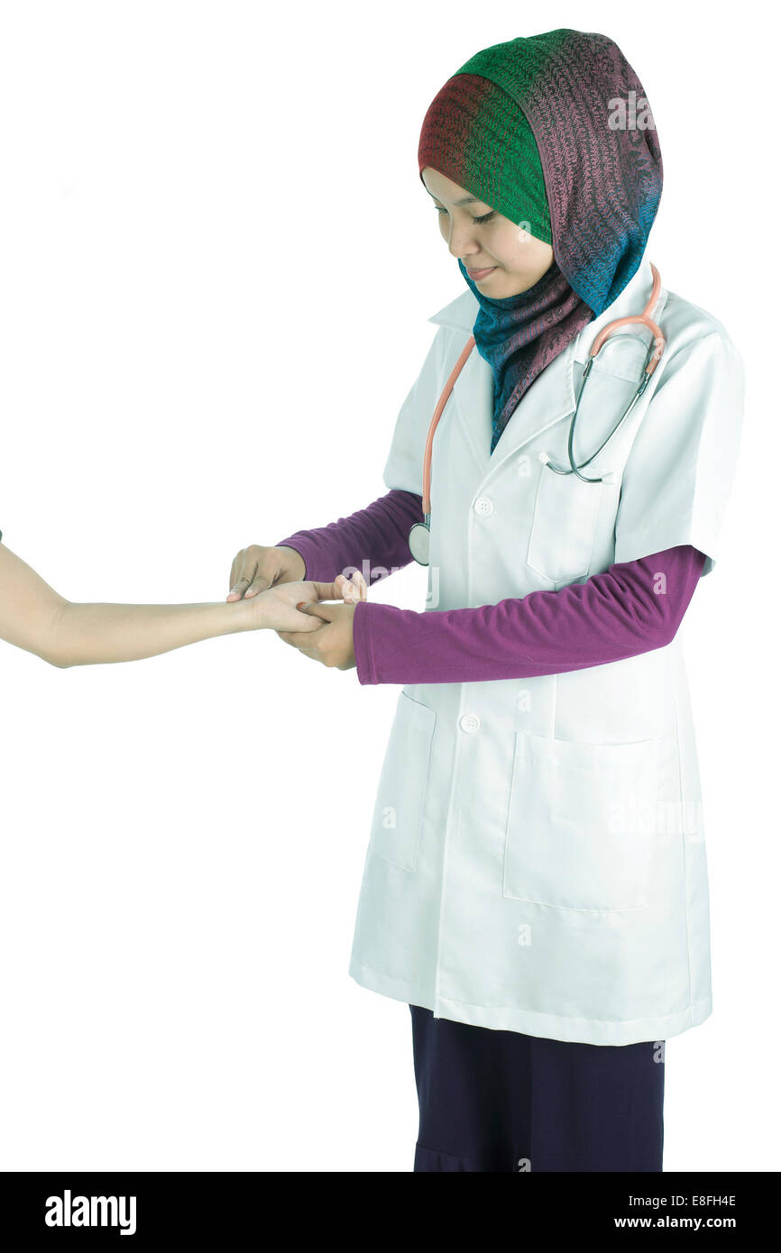 Portrait of a muslimah doctor checking a patient's pulse Stock Photo ...