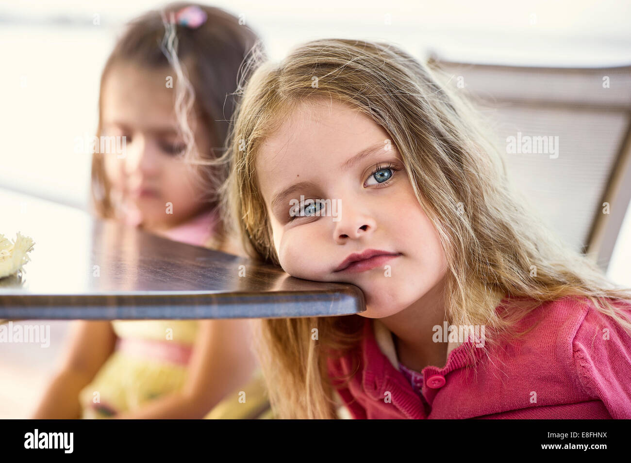 Girl resting her head on a table Stock Photo - Alamy